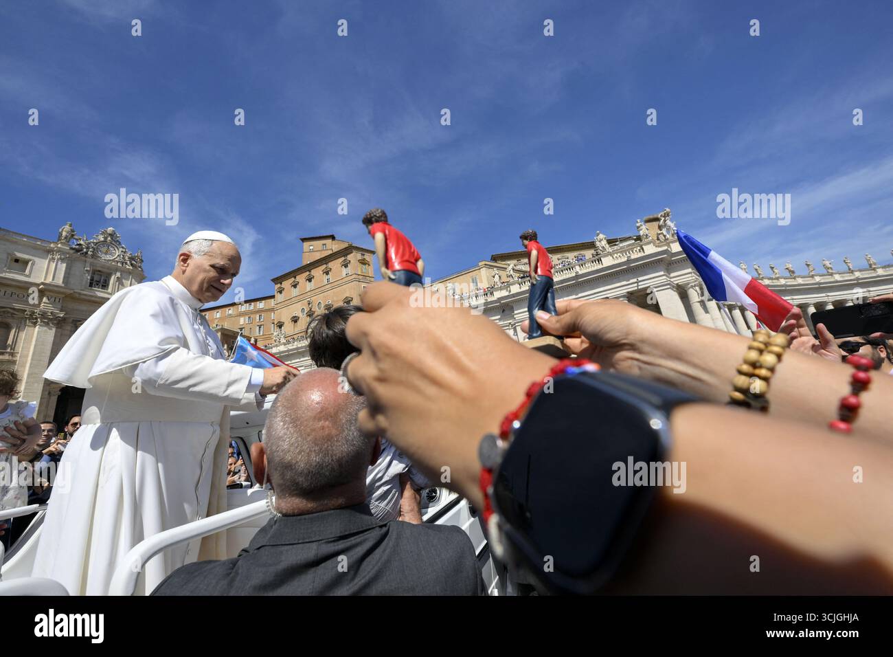 A pilgrim shows two statuettes of new saint Carlo Acutis to Pope Leo ...