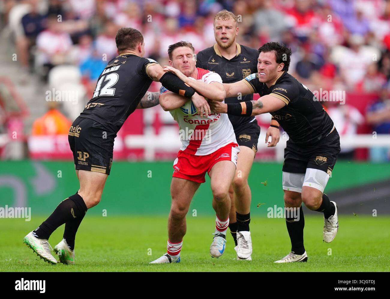 Hull KR's Tom Davies (centre) is tackled by Hull FC's Jordan Lane (left ...
