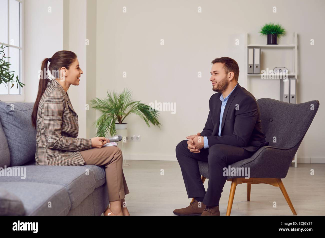 A journalist conducts a corporate interview with a happy businessman ...