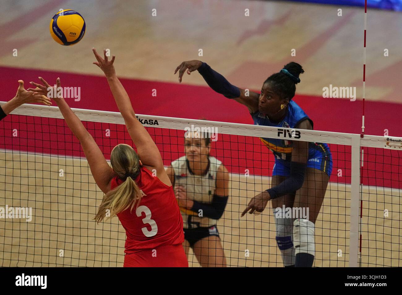 Myriam Fatime Sylla, of Italy spikes the ball over Cansu Özbay, of ...