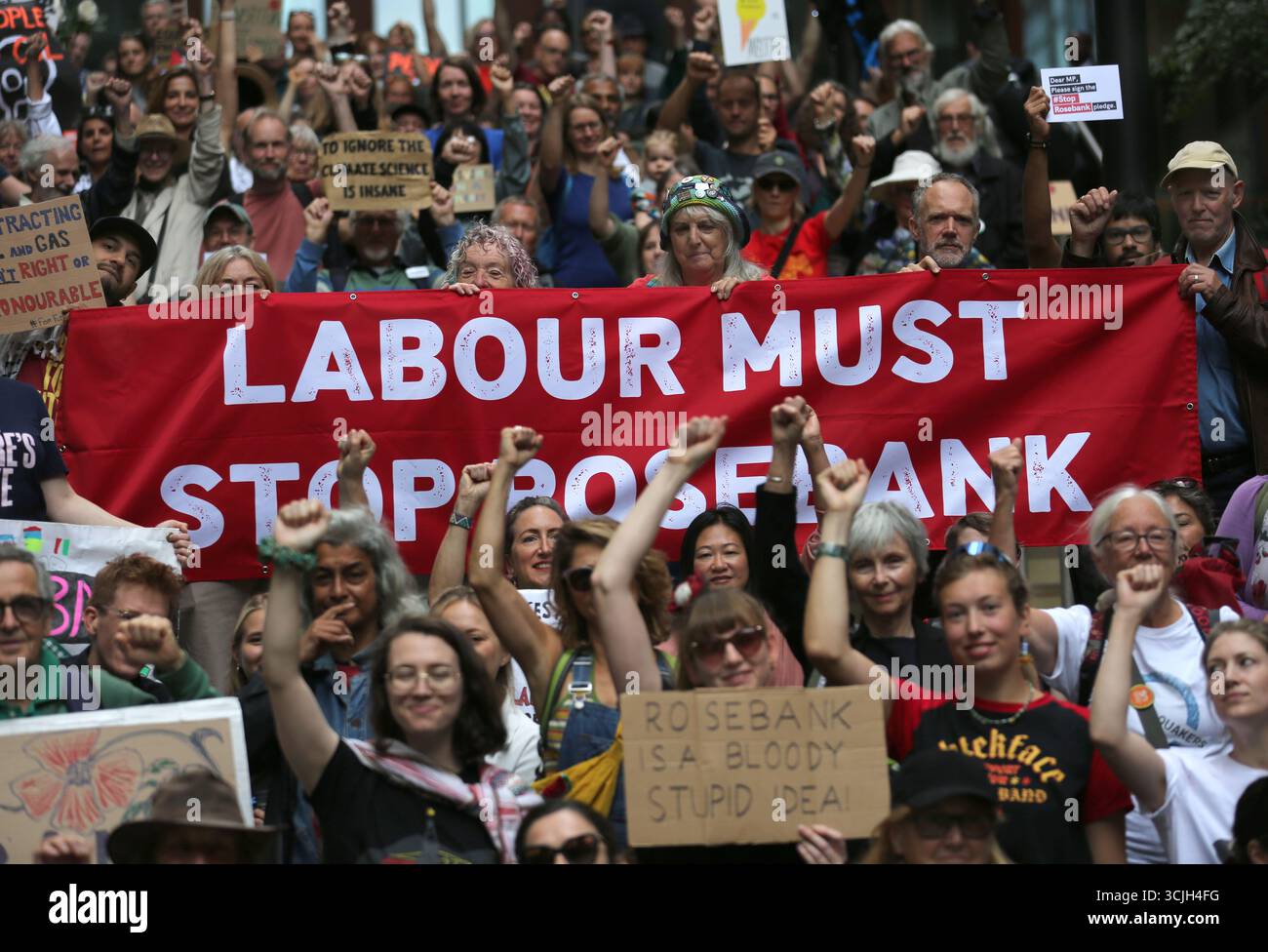 Protesters gather together with a large banner saying ‘Labour Must Stop ...