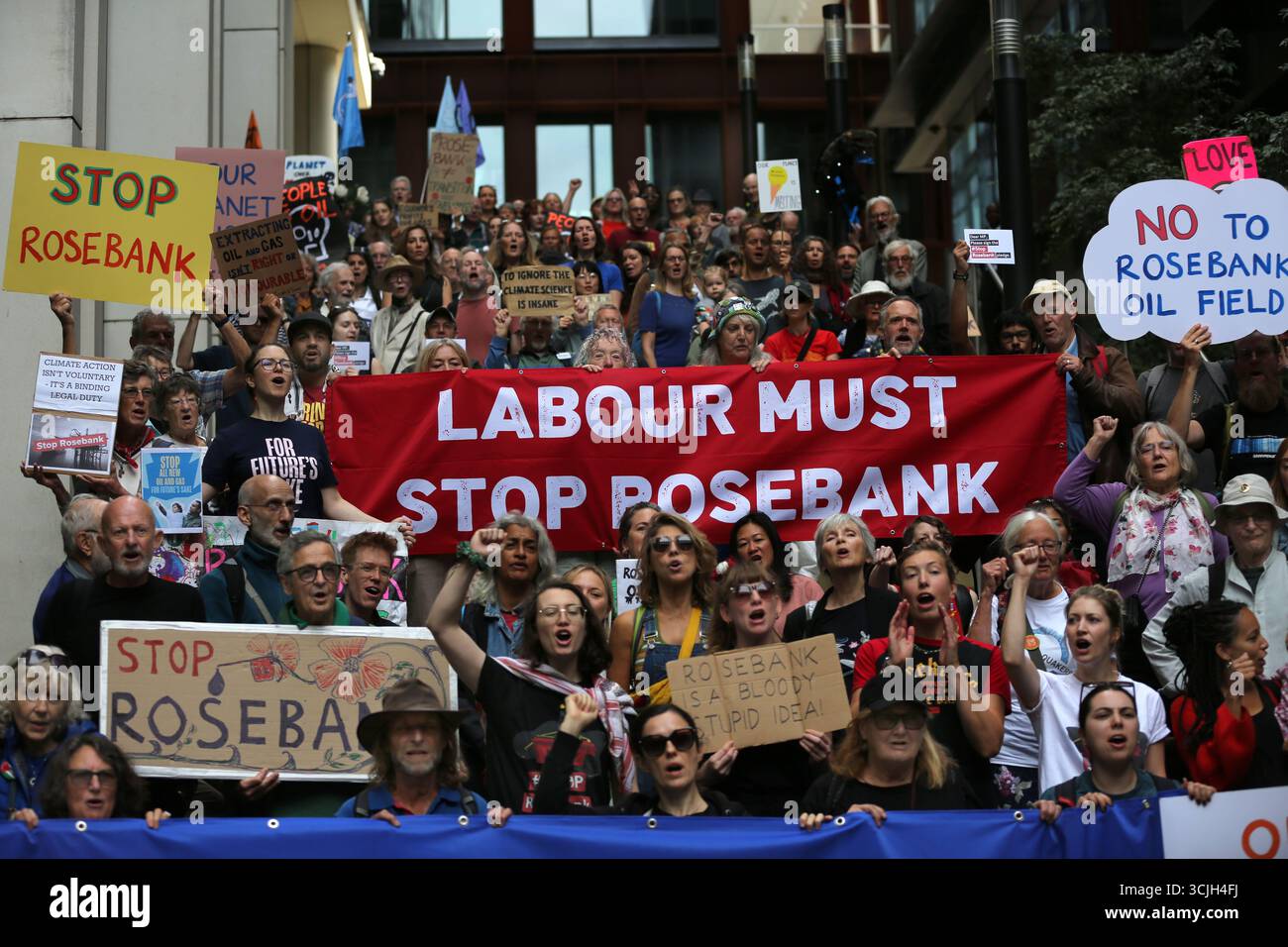 Protesters gather together with a large banner saying ‘Labour Must Stop ...