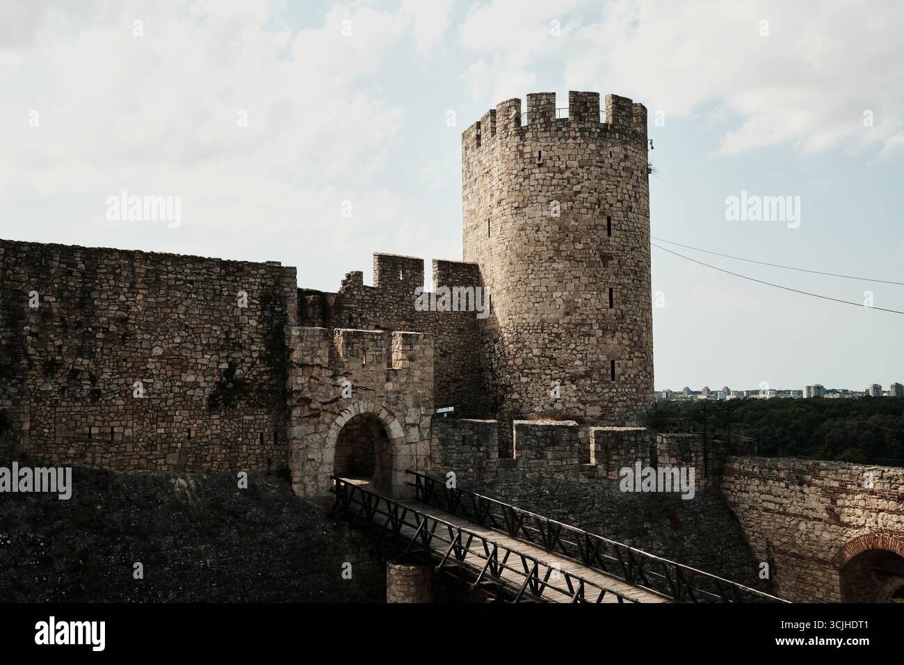 Round tower and stone walls of Kalemegdan Fortress with wooden bridge ...