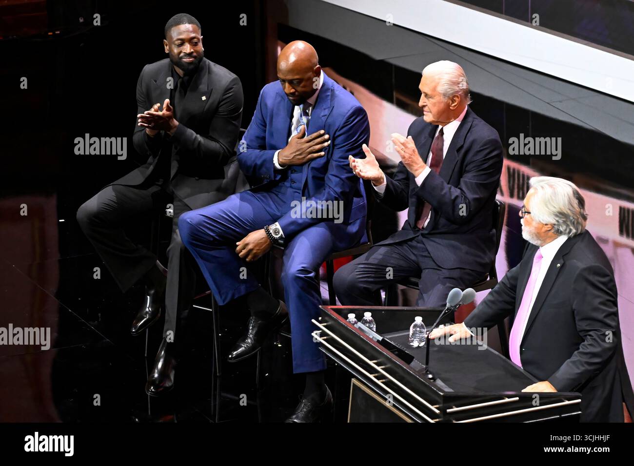 Micky Arison, right, speaks to Alonzo Mourning, as Dwyane Wade, left ...