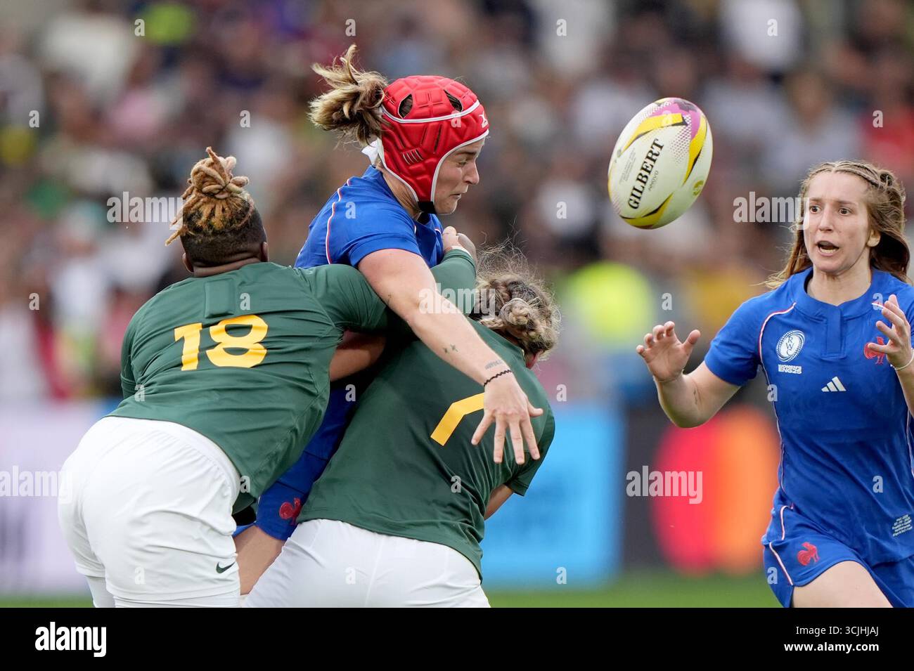 France's Charlotte Escudero offloads the ball as she is tackled by ...