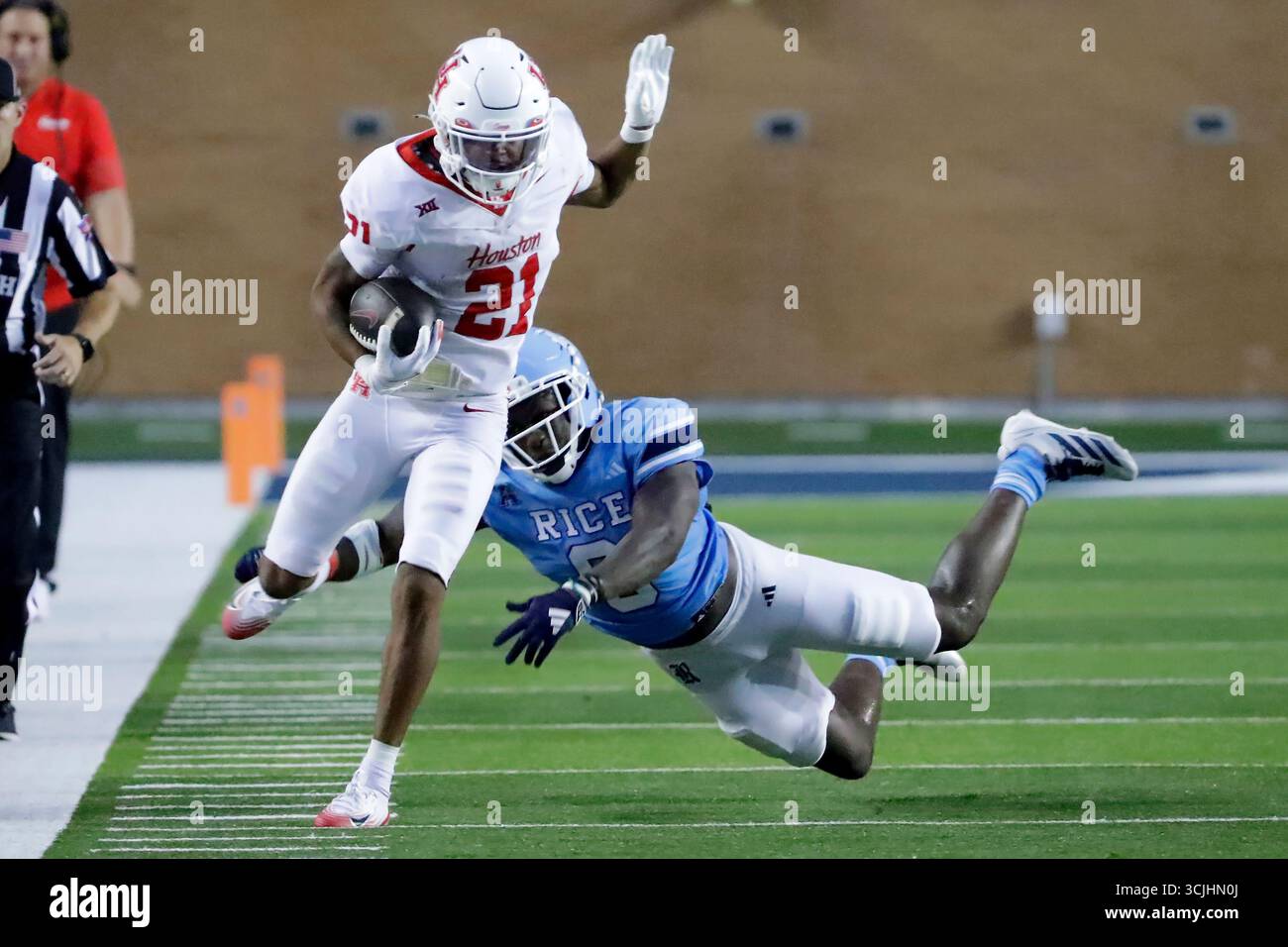 Houston running back Stacy Sneed (21) breaks the tackle attempt by Rice ...