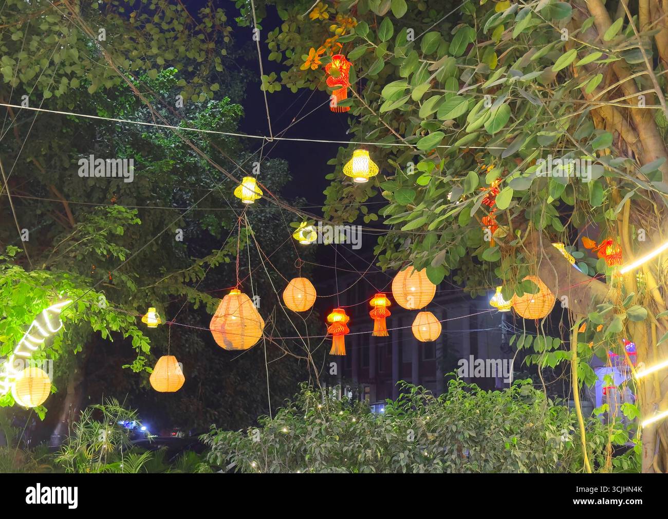 Red lanterns hanging among trees hi-res stock photography and images ...