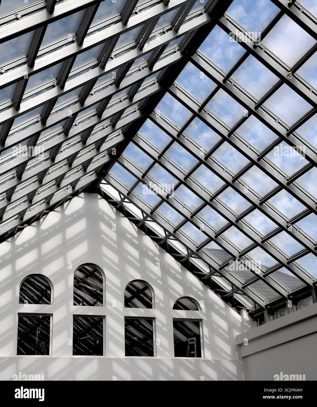 Modern architectural interior with a large geometric glass ceiling that ...