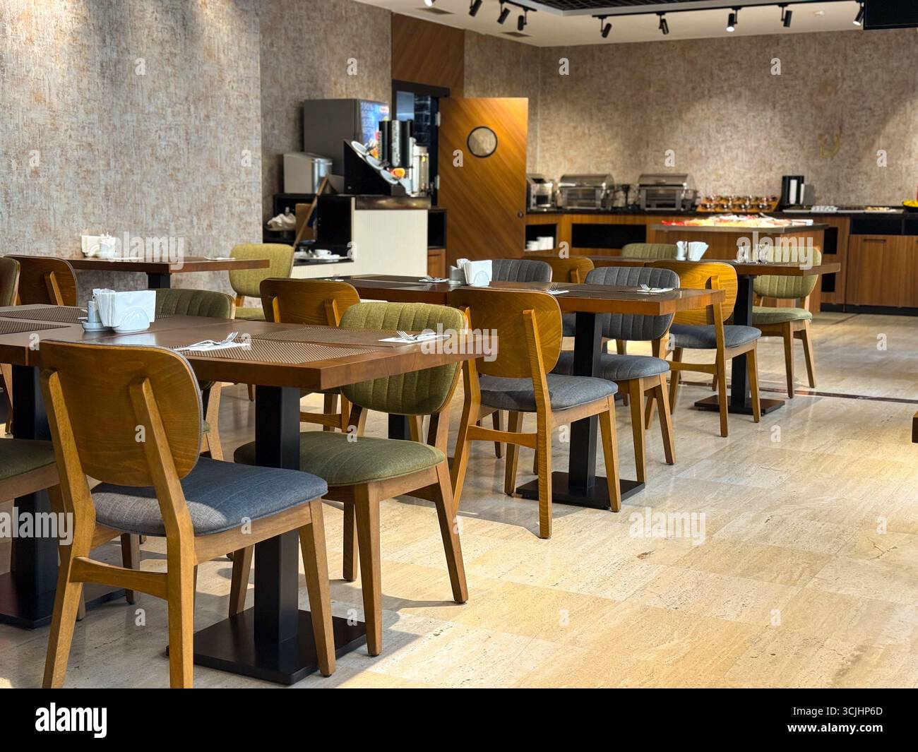 Dining hall with wooden tables and chairs arranged neatly in a modern ...
