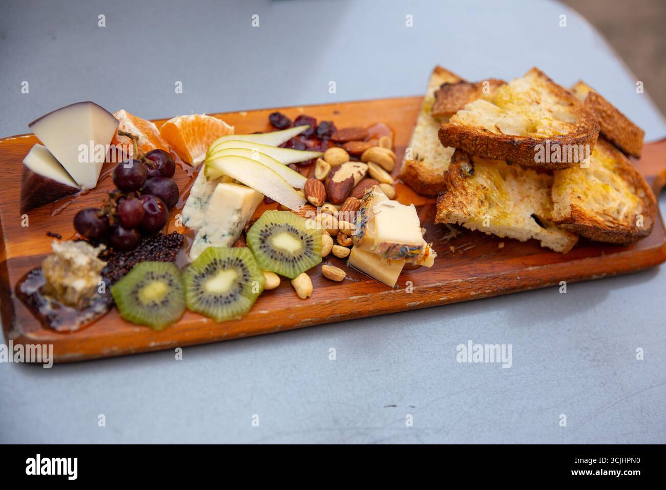 Fruits, cheese and nuts board with toasted bread Stock Photo - Alamy
