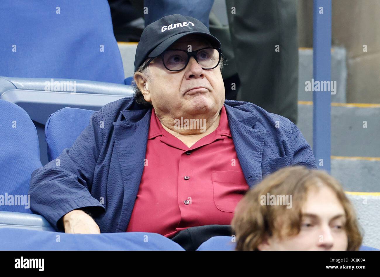 Flushing Meadows, United States. 07th Sep, 2025. Danny DeVito sits in ...