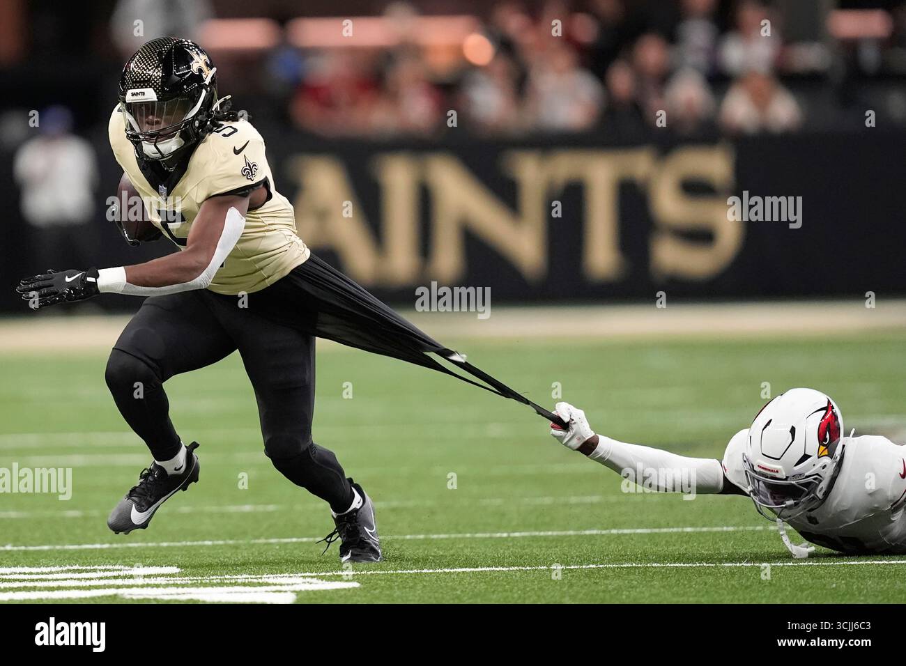 New Orleans Saints running back Kendre Miller, left, pulls away from ...