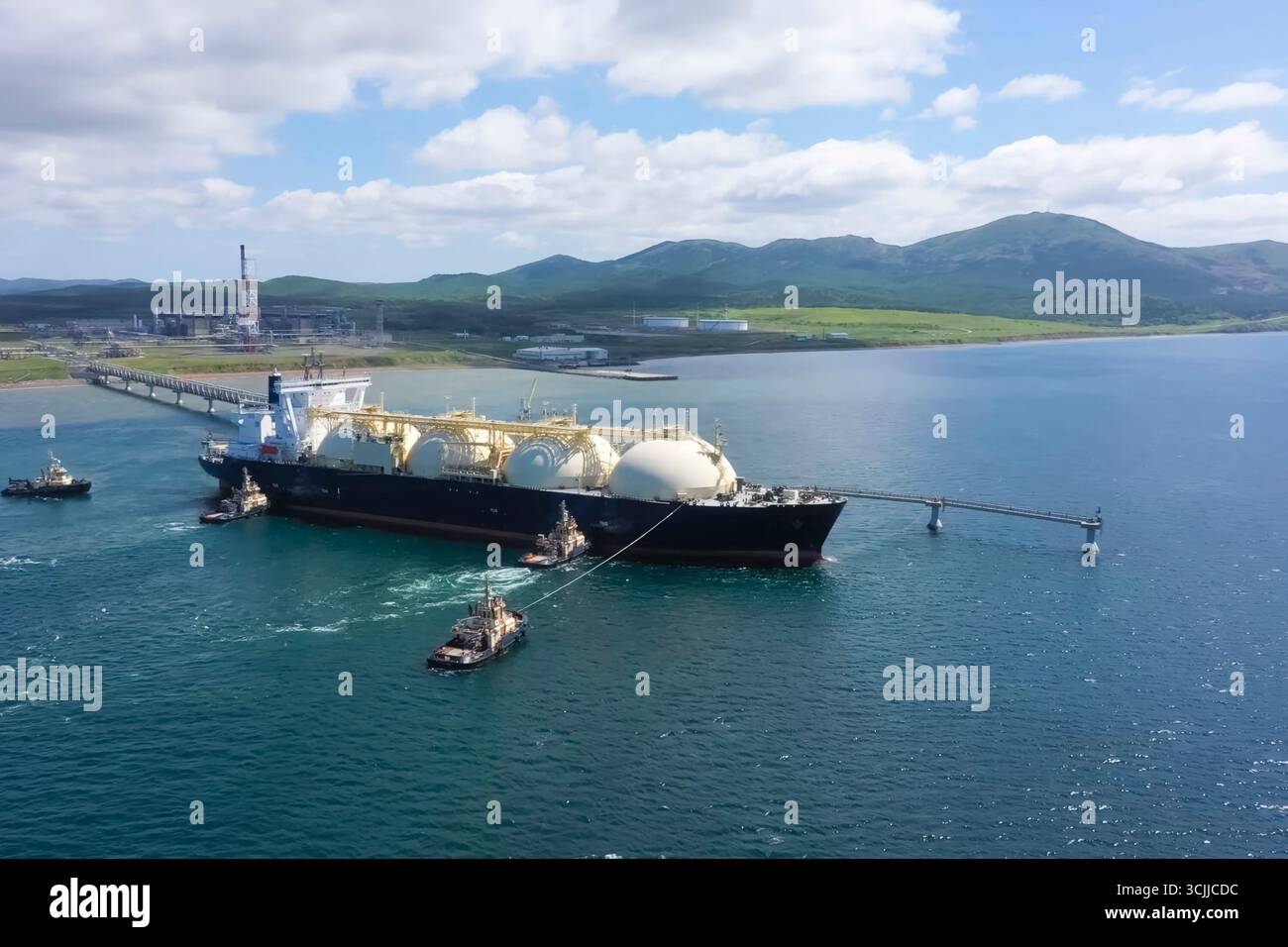 A tanker with liquefied natural gas in a port with a fueling terminal ...