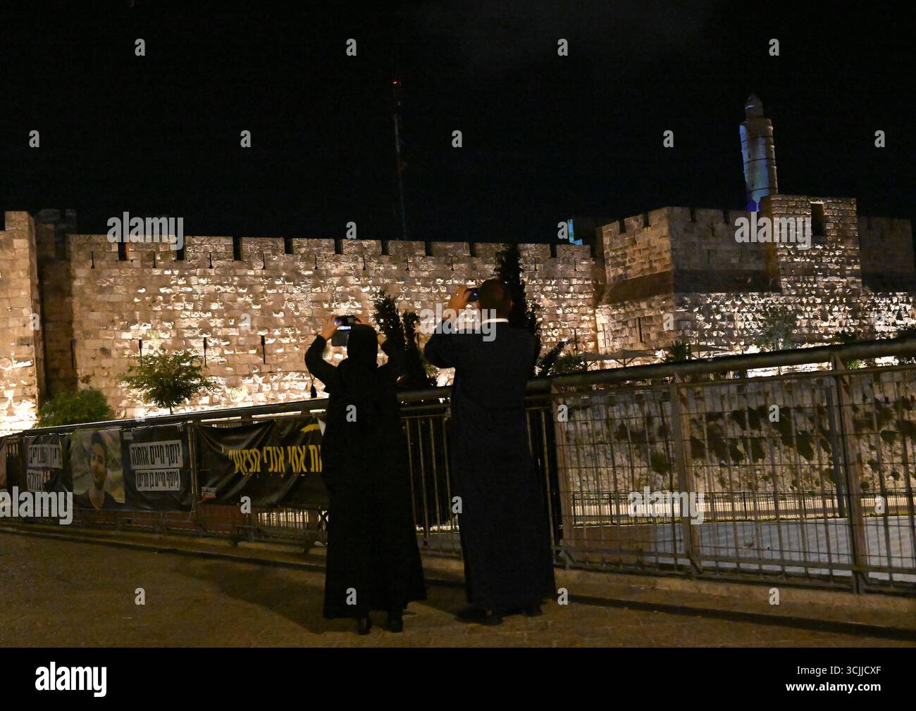 A nun and priest take photos of the lunar eclipse near the Tower of ...