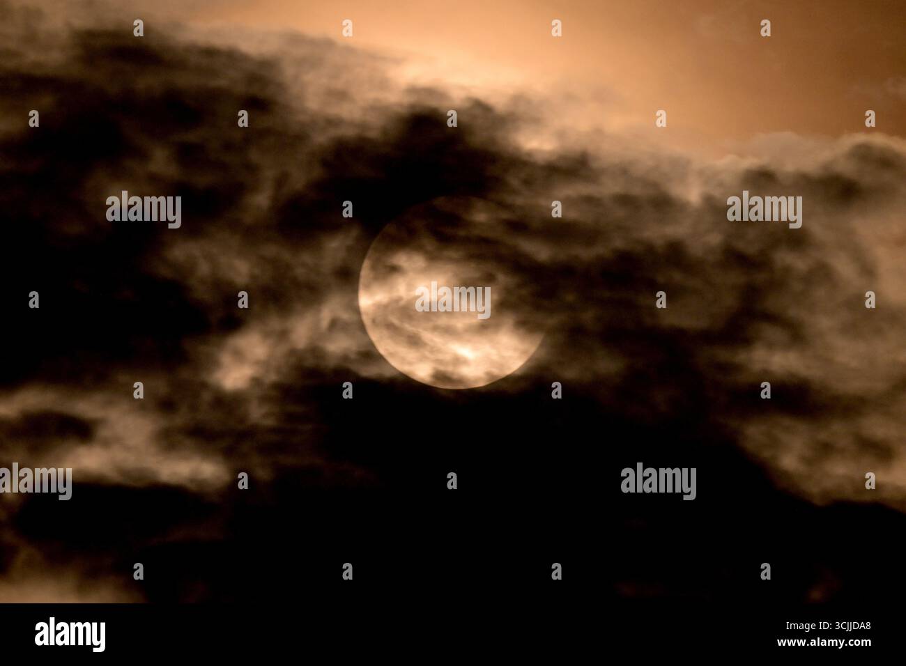 Essex, UK. 7th Sep, 2025. The Full Blood Moon Lunar Eclipse rises over a cloudy south of England ...