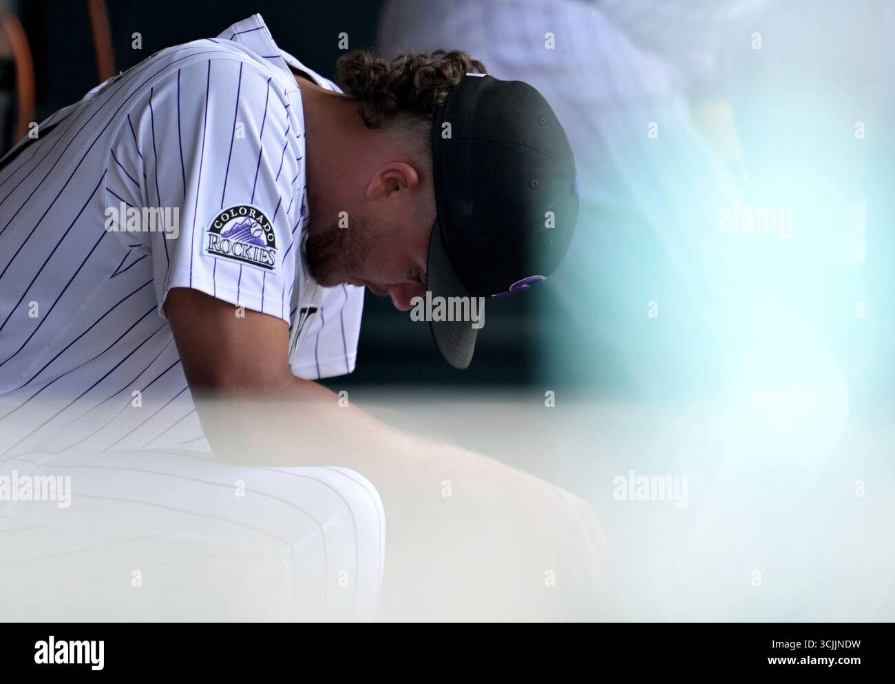 Colorado Rockies relief pitcher Luis Peralta pauses in the dugout after ...