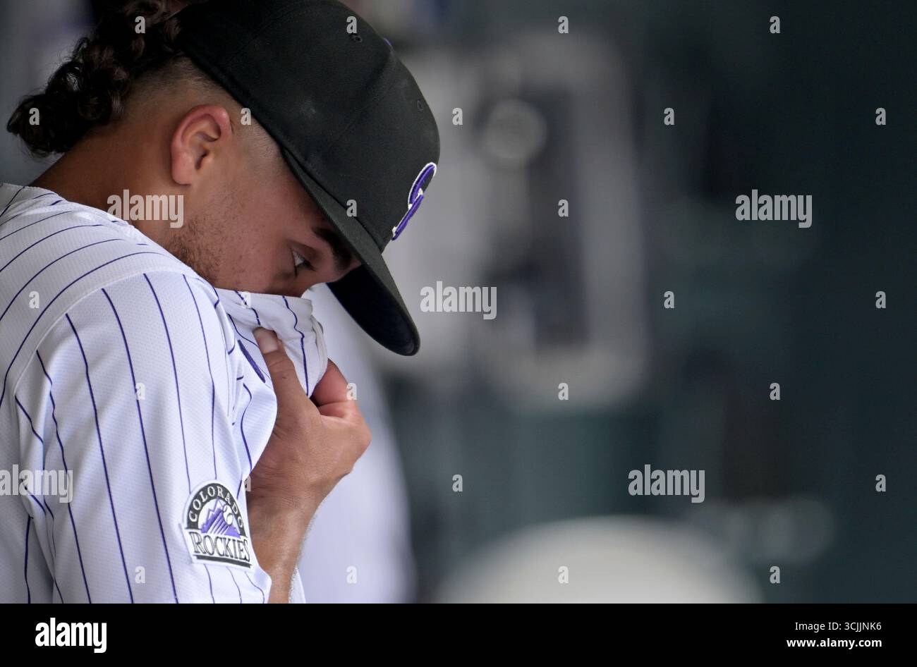 Colorado Rockies relief pitcher Luis Peralta pauses in the dugout after ...