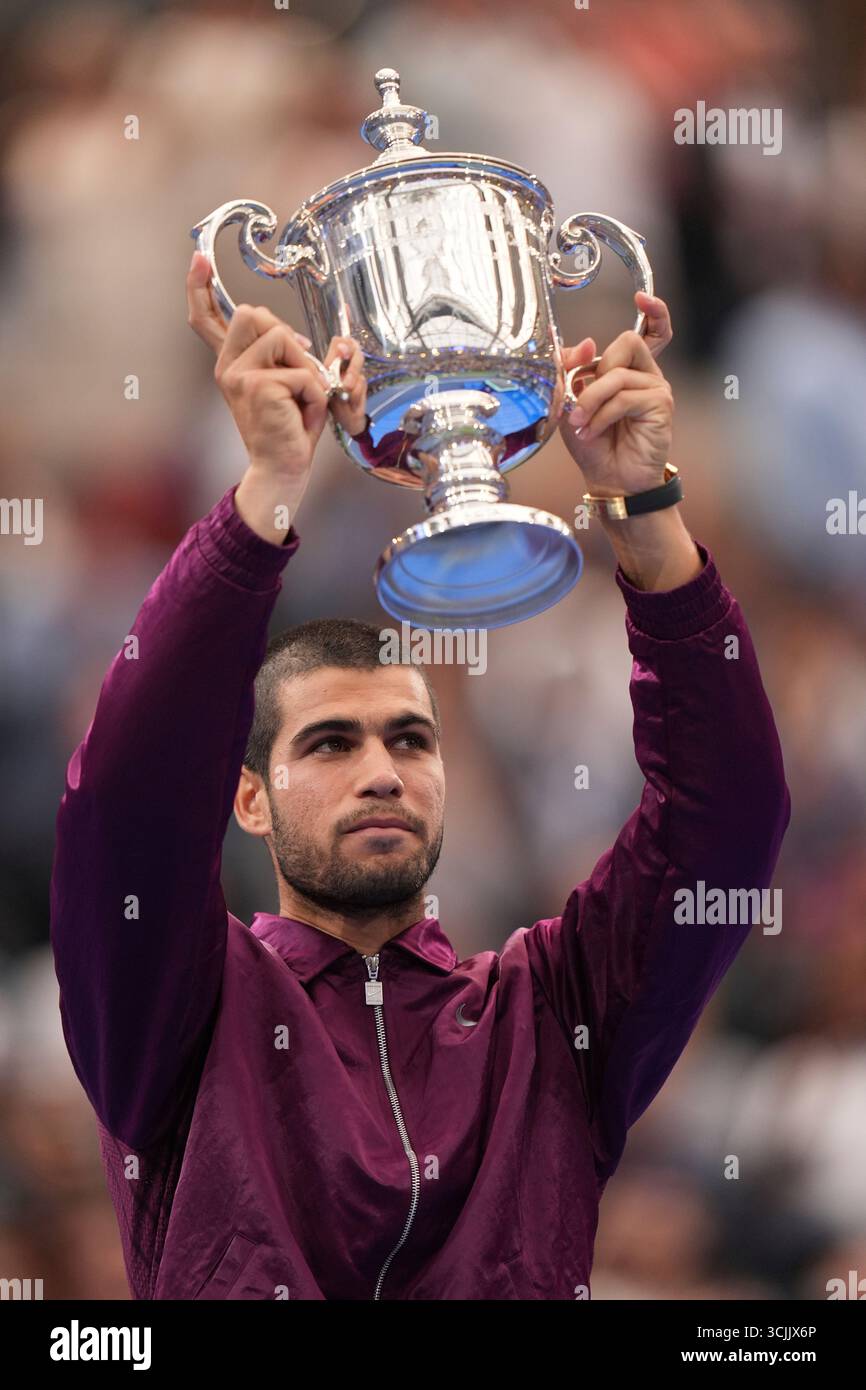 Carlos Alcaraz, of Spain, lifts the championship trophy after defeating Jannik Sinner, of Italy ...