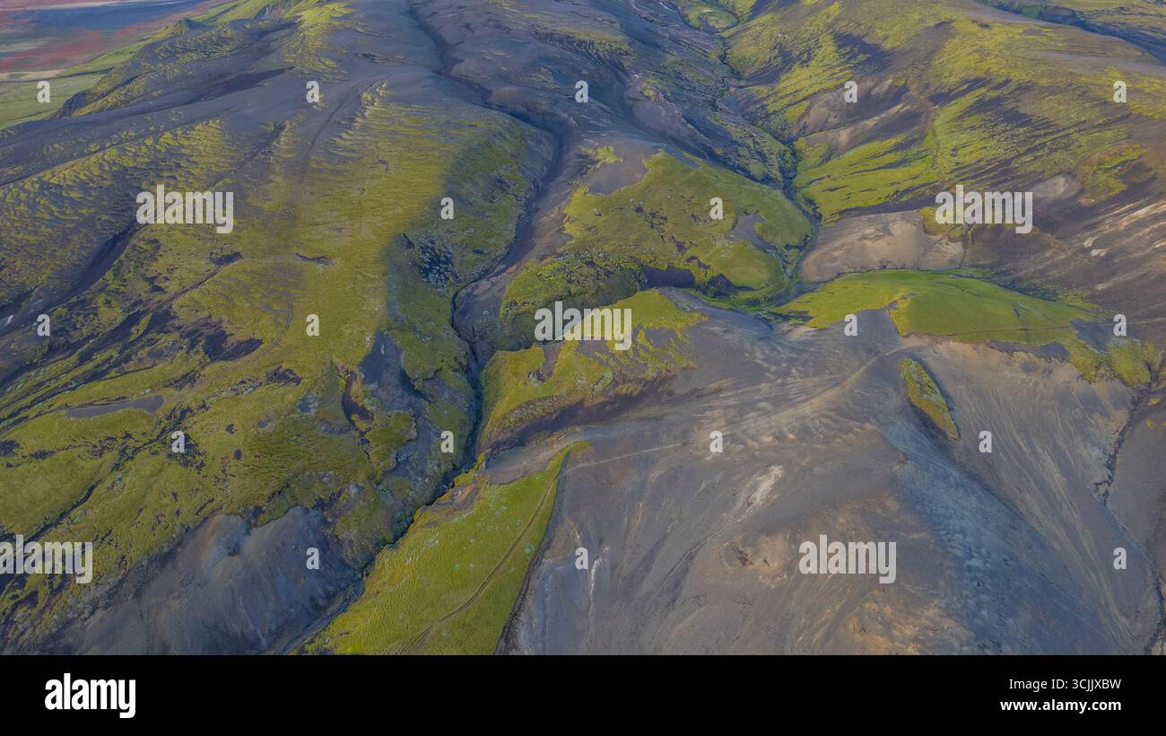 Aerial view of Icelandic highlands with black volcanic slopes green ...