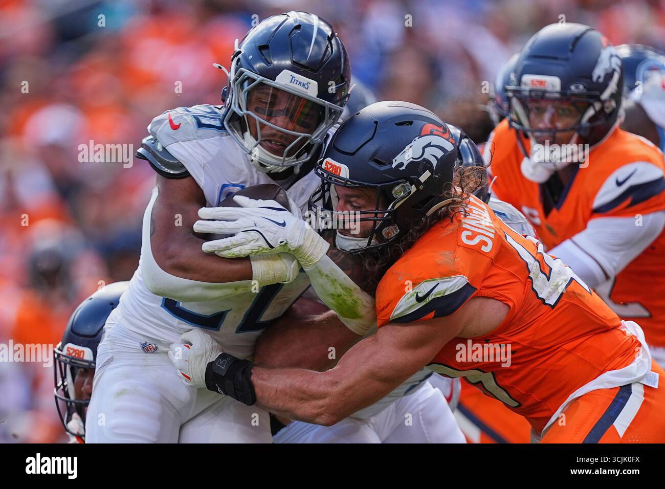 Tennessee Titans running back Tony Pollard, left, is tackled by Denver ...
