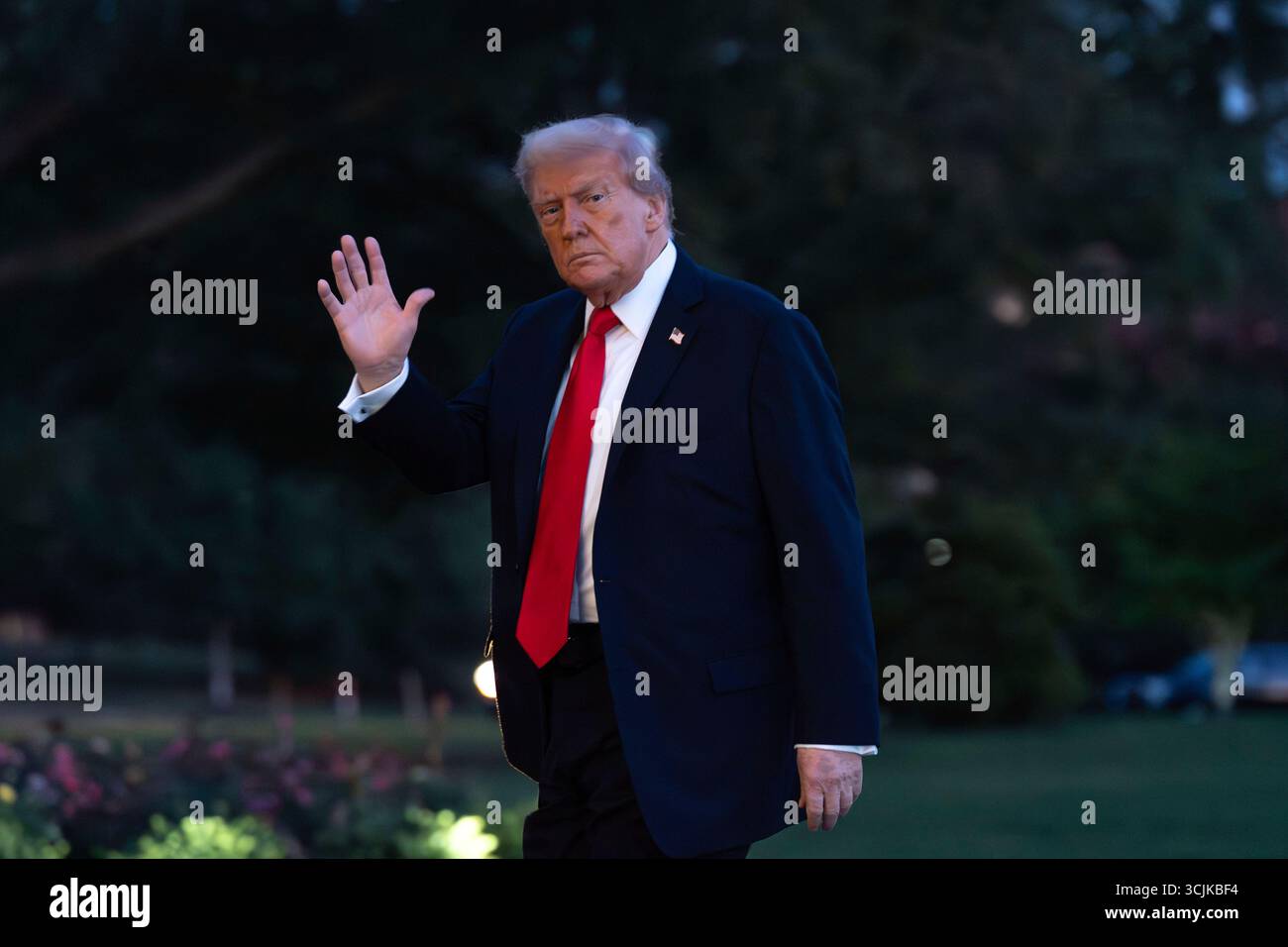 President Donald Trump waves to reporters as he walks on the South Lawn ...