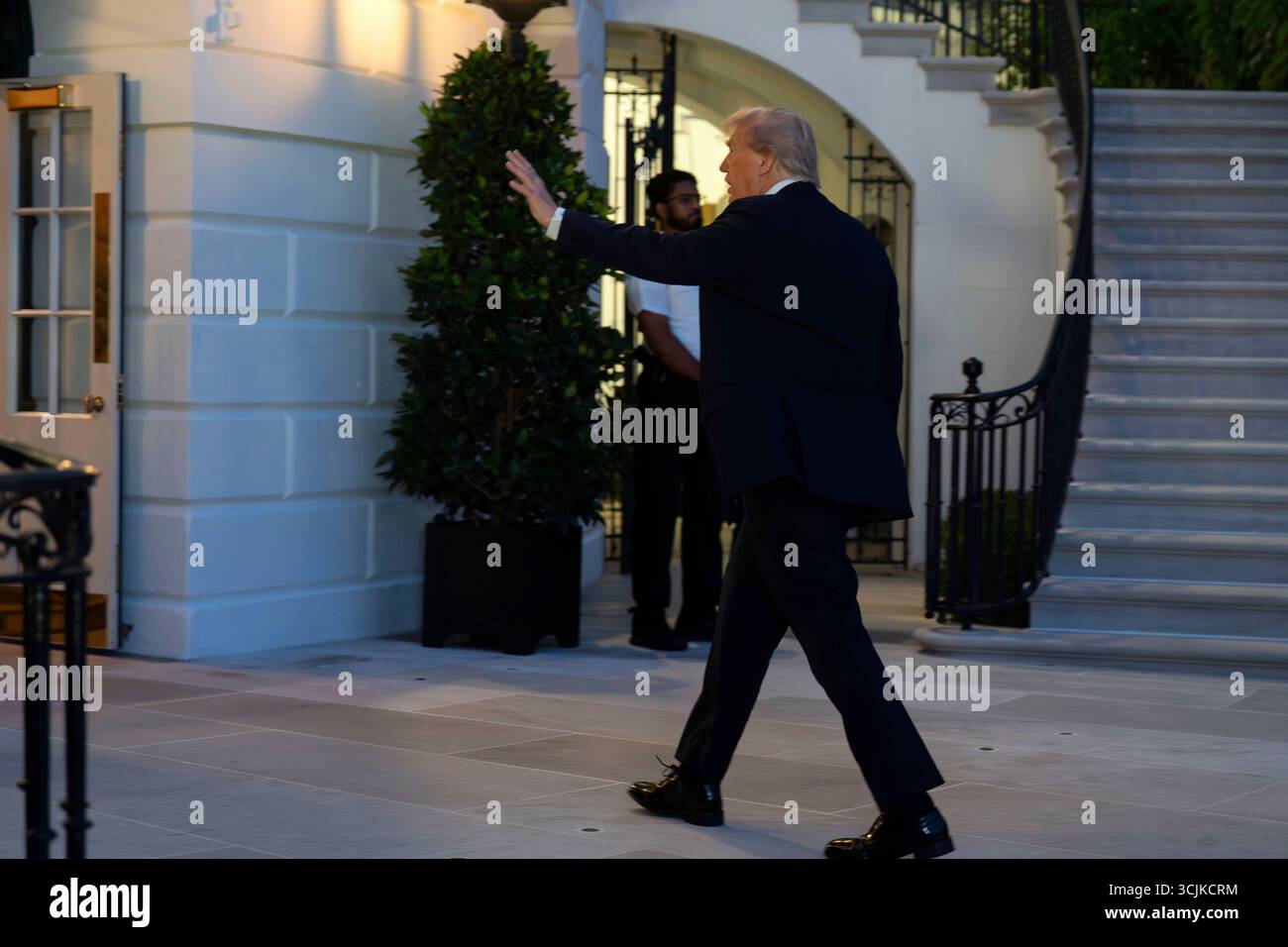 President Donald Trump waves as he walks on the South Lawn upon his ...