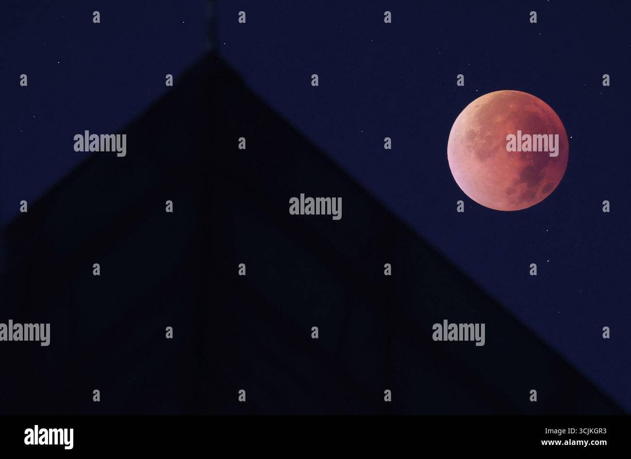 A total lunar eclipse is observed above the Moerenuma Park's "Glass ...