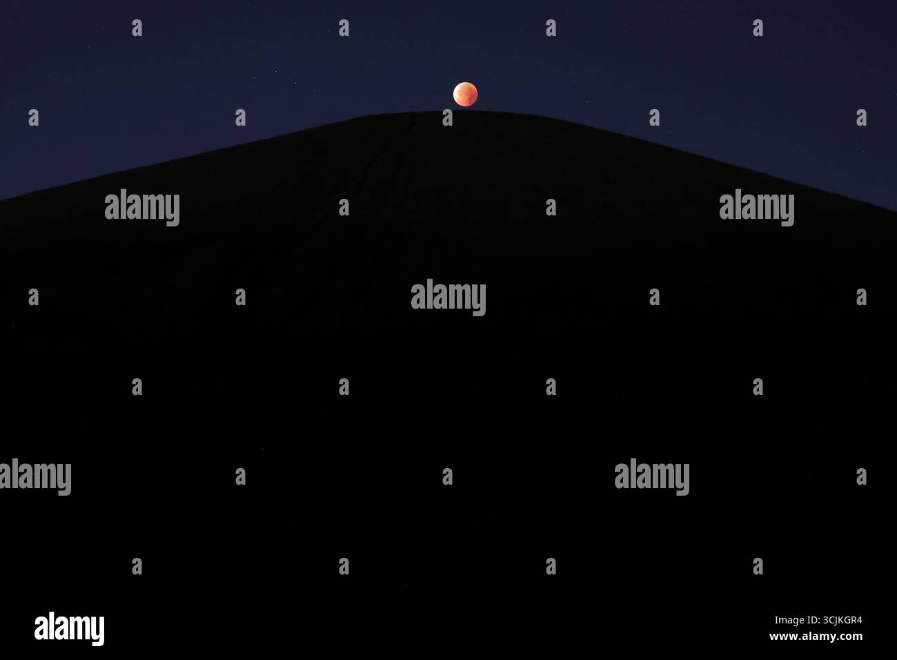 A total lunar eclipse is observed above the Moerenuma Park's "Glass ...