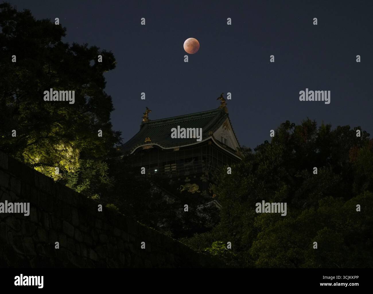 A total lunar eclipse is seen above Osaka Castle in the western Japan ...