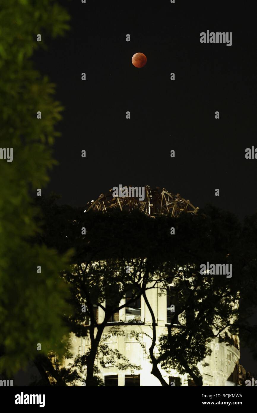 A total lunar eclipse is seen above the Atomic Bomb Dome in the western ...