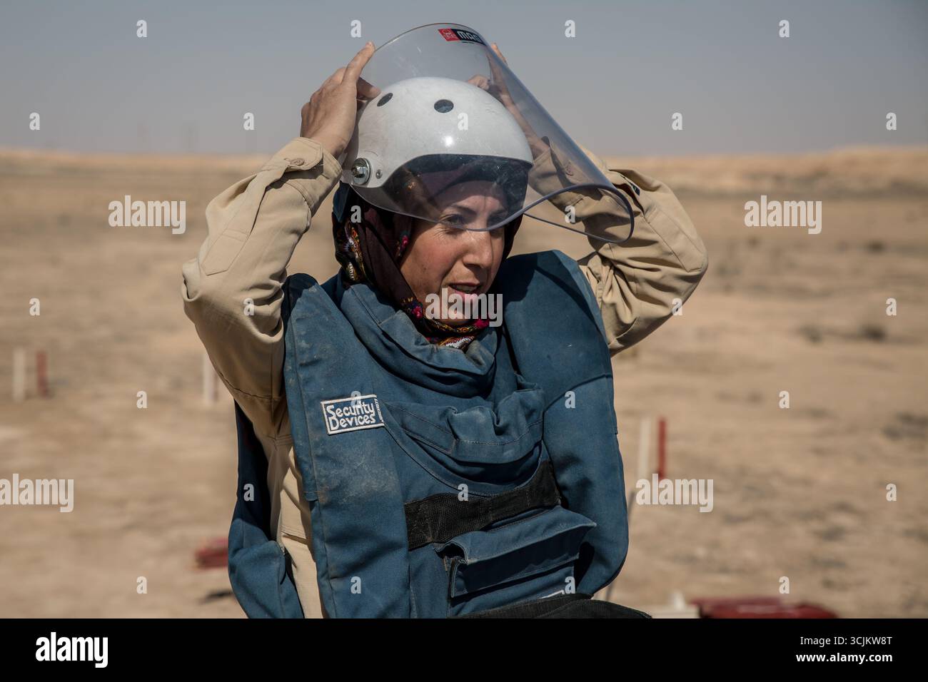 A deminer from the Mines Advisory Group puts on protective gear ahead ...