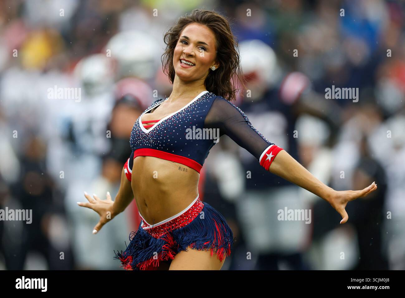 A New England Patriots cheerleader performs during the first half of an NFL football game ...