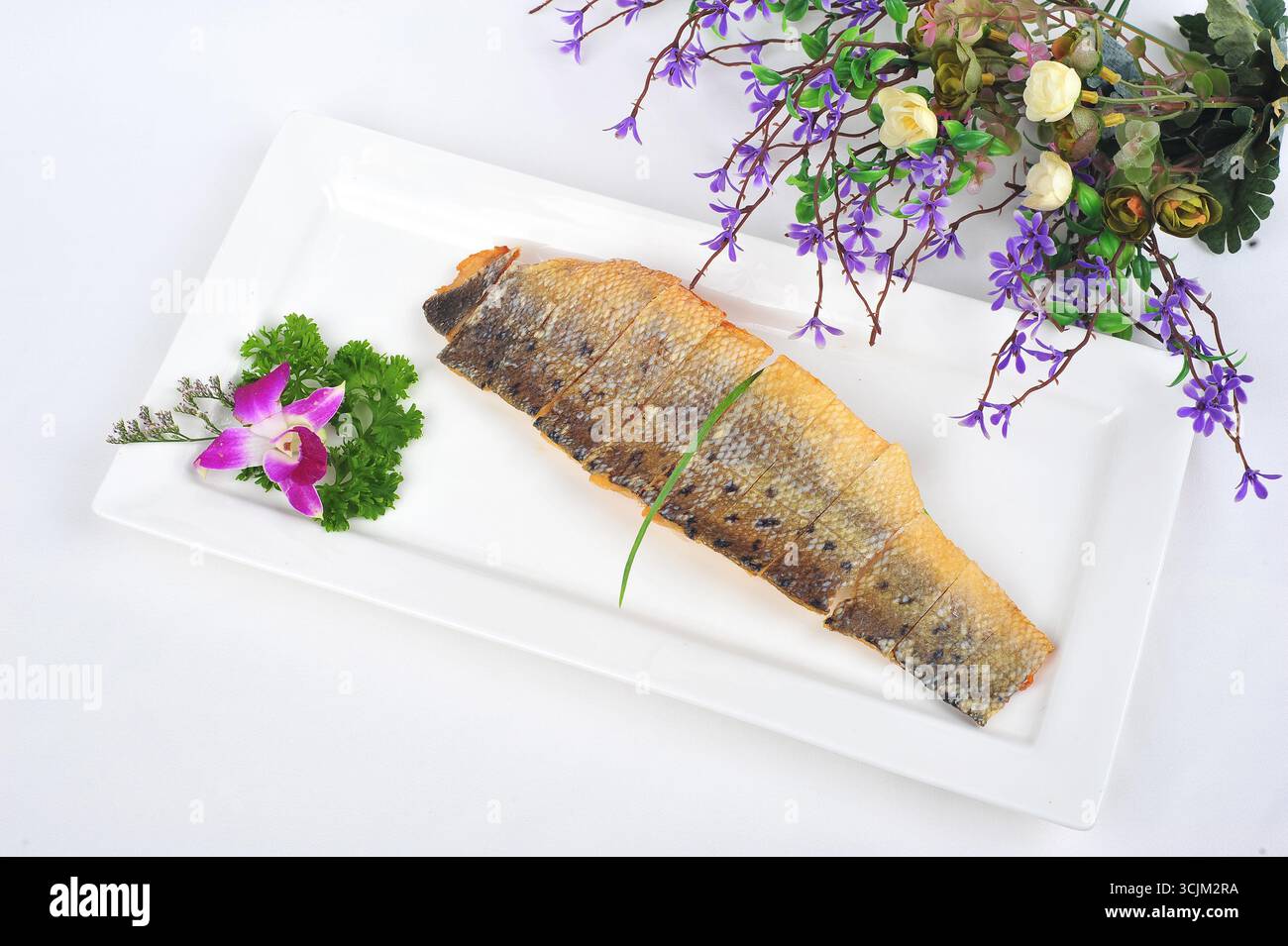 Crispy Fried Scaled Sea Bass, Sliced on White Porcelain Plate Stock ...