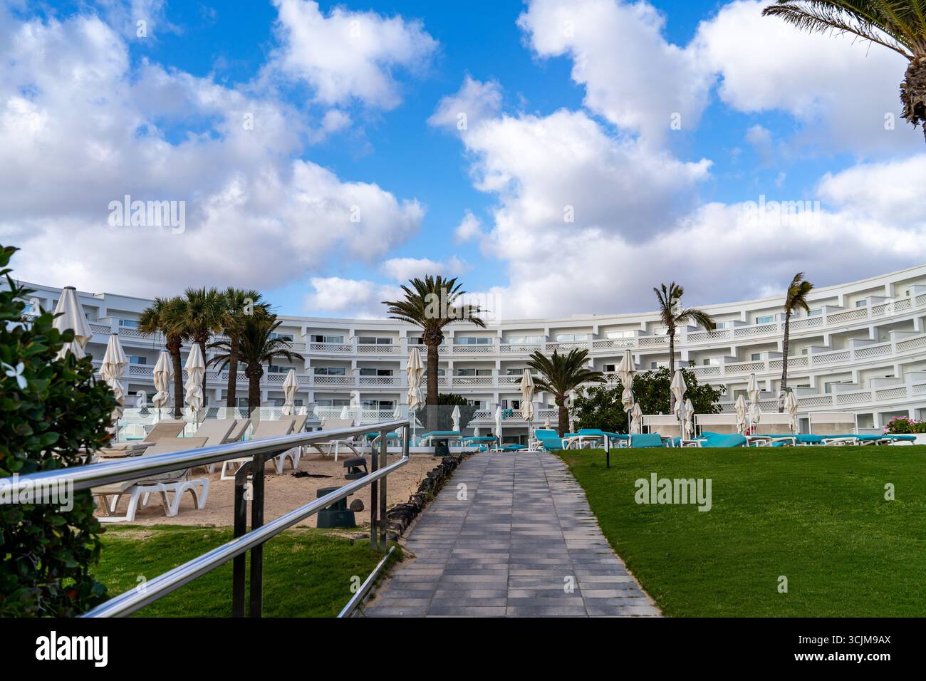 The curved architecture of a resort in Lanzarote is framed by palm ...