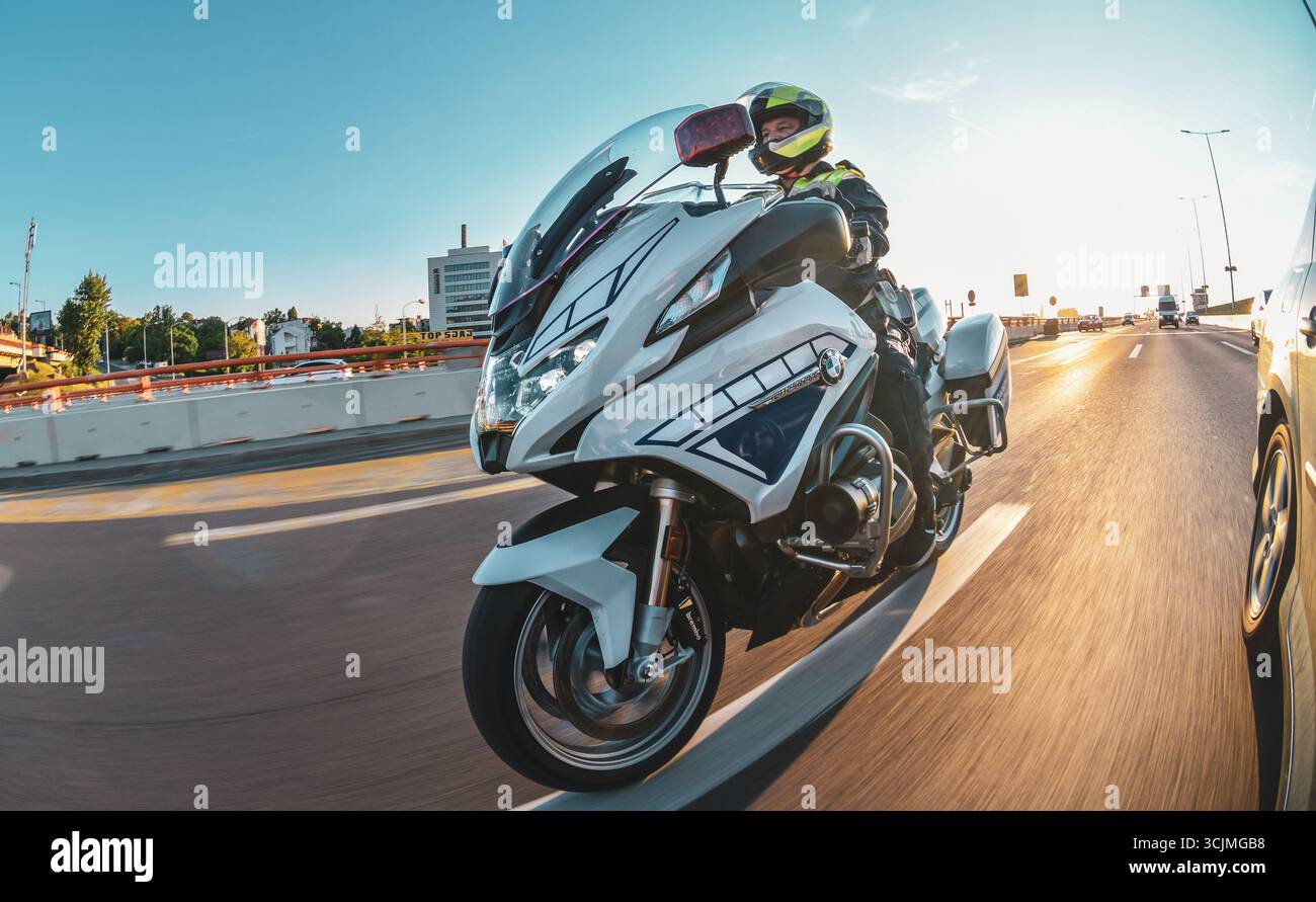 Police officer riding BMW motorcycle with flashing lights on highway ...