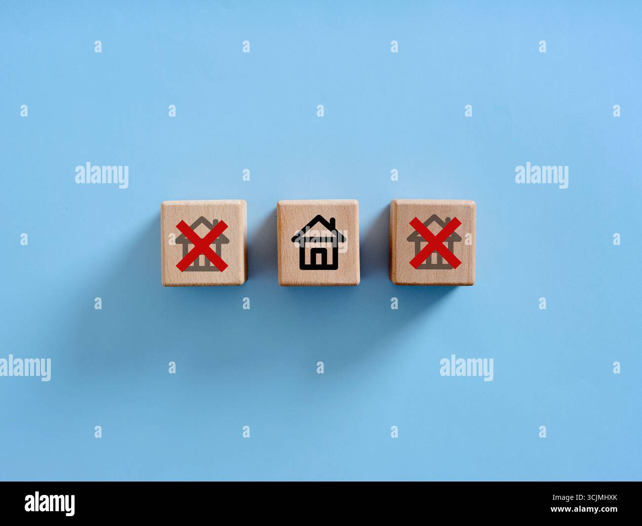 Wooden cubes with house icons, two crossed out, suggesting choosing the ...