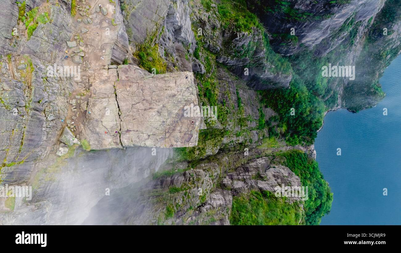 Dramatic cliffs tower over the majestic fjord below as adventurers ...