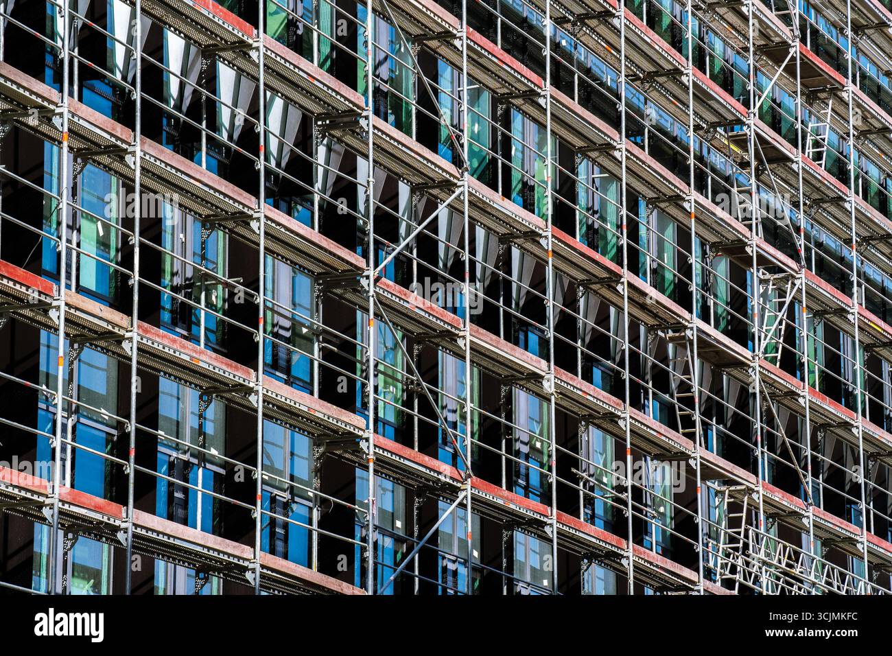 Office building under construction with scaffolding grid covering glass ...