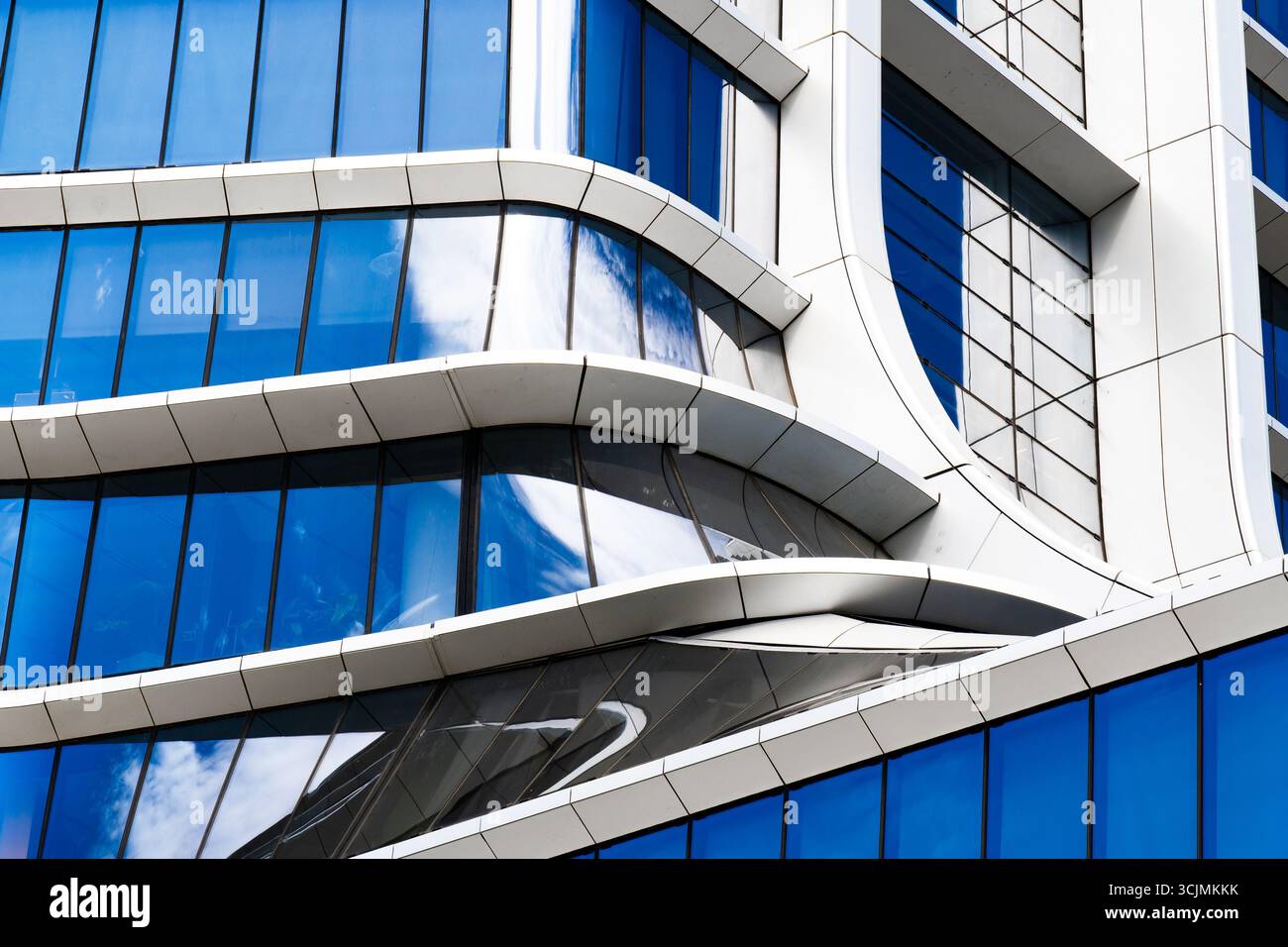 Futuristic office building with curved white structures and reflective ...