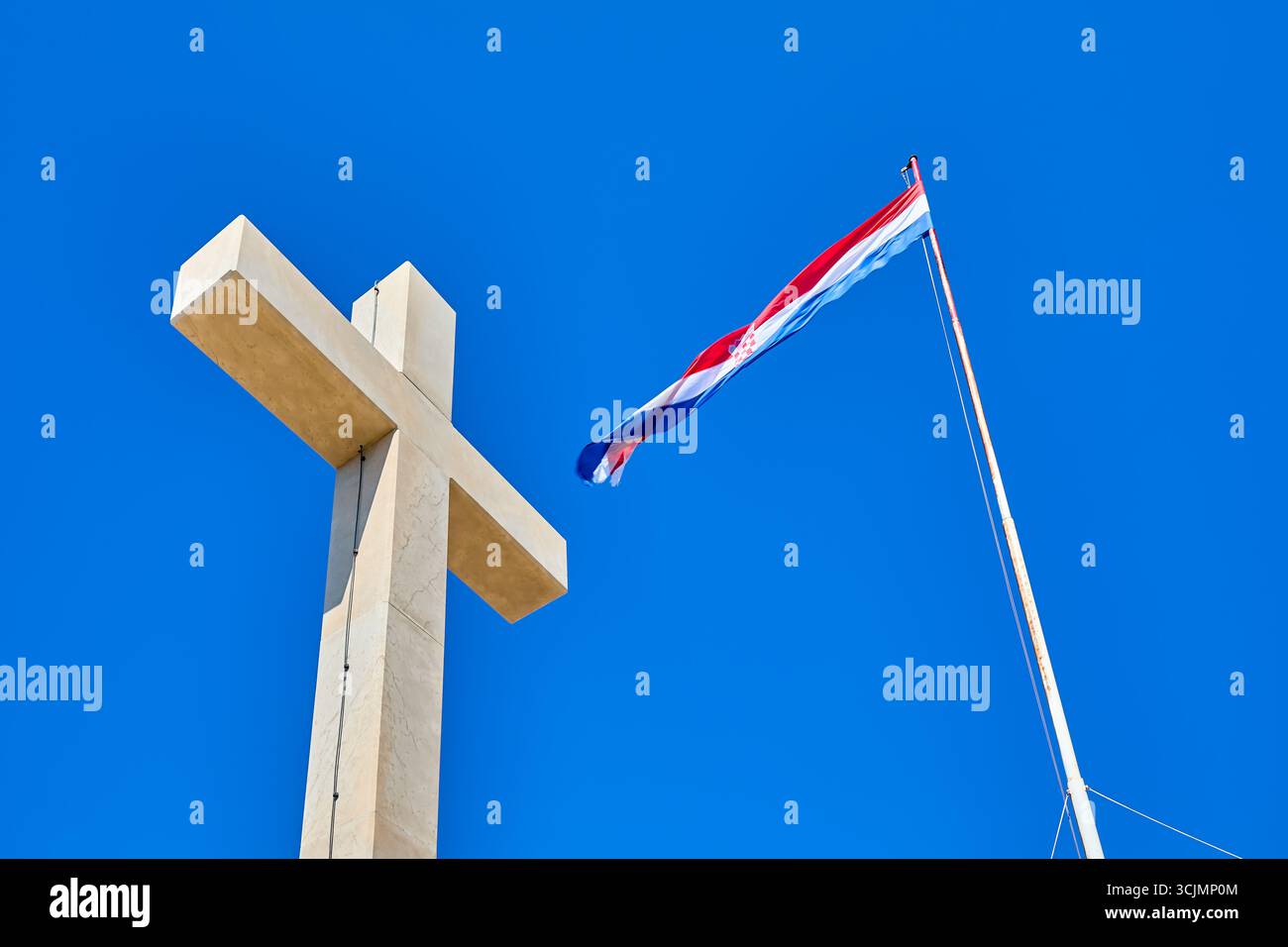 Religious cross monument with Croatian Flag with clear blue sky ...
