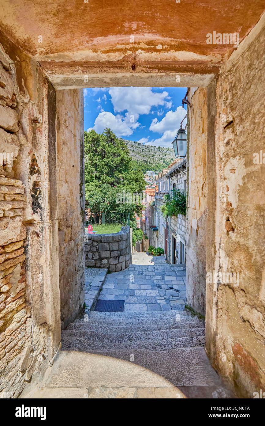 Rising stone steps in narrow alley walkways between old town buildings ...
