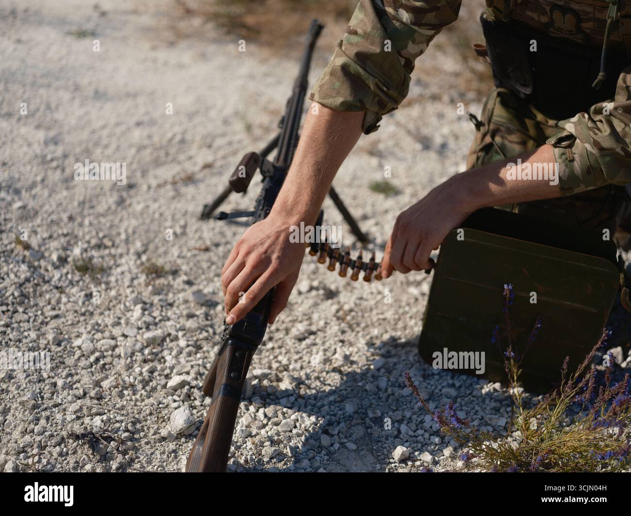 Close up view of Ukrainian military man hands loading ammunition belt ...