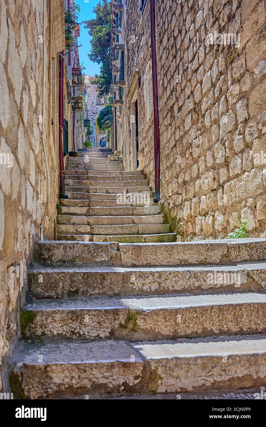 Rising stone steps in narrow alley walkways between old town buildings ...