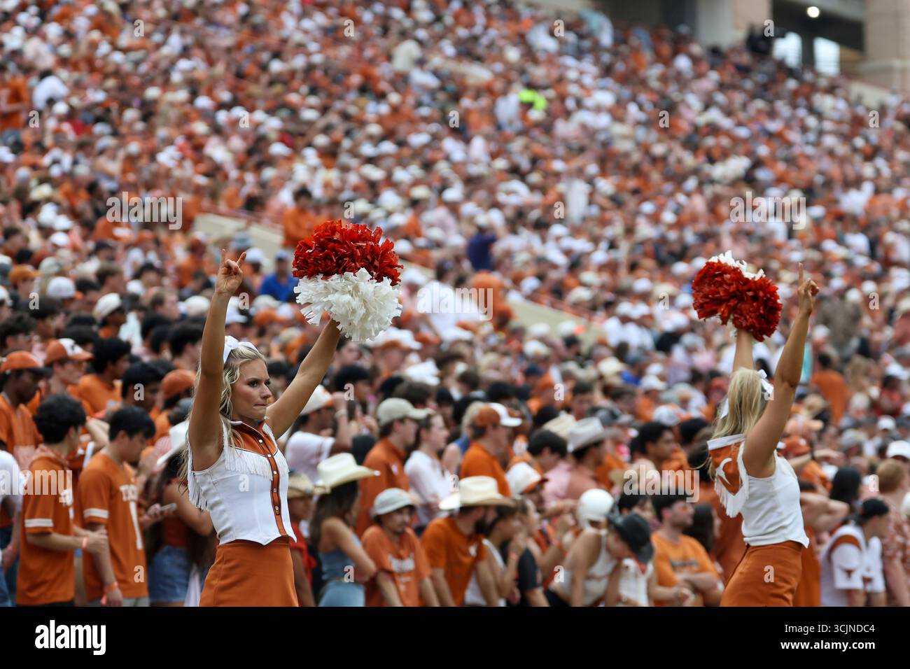 AUSTIN, TX - SEPTEMBER 06: Texas cheerleaders hold Horns Up sign with a ...