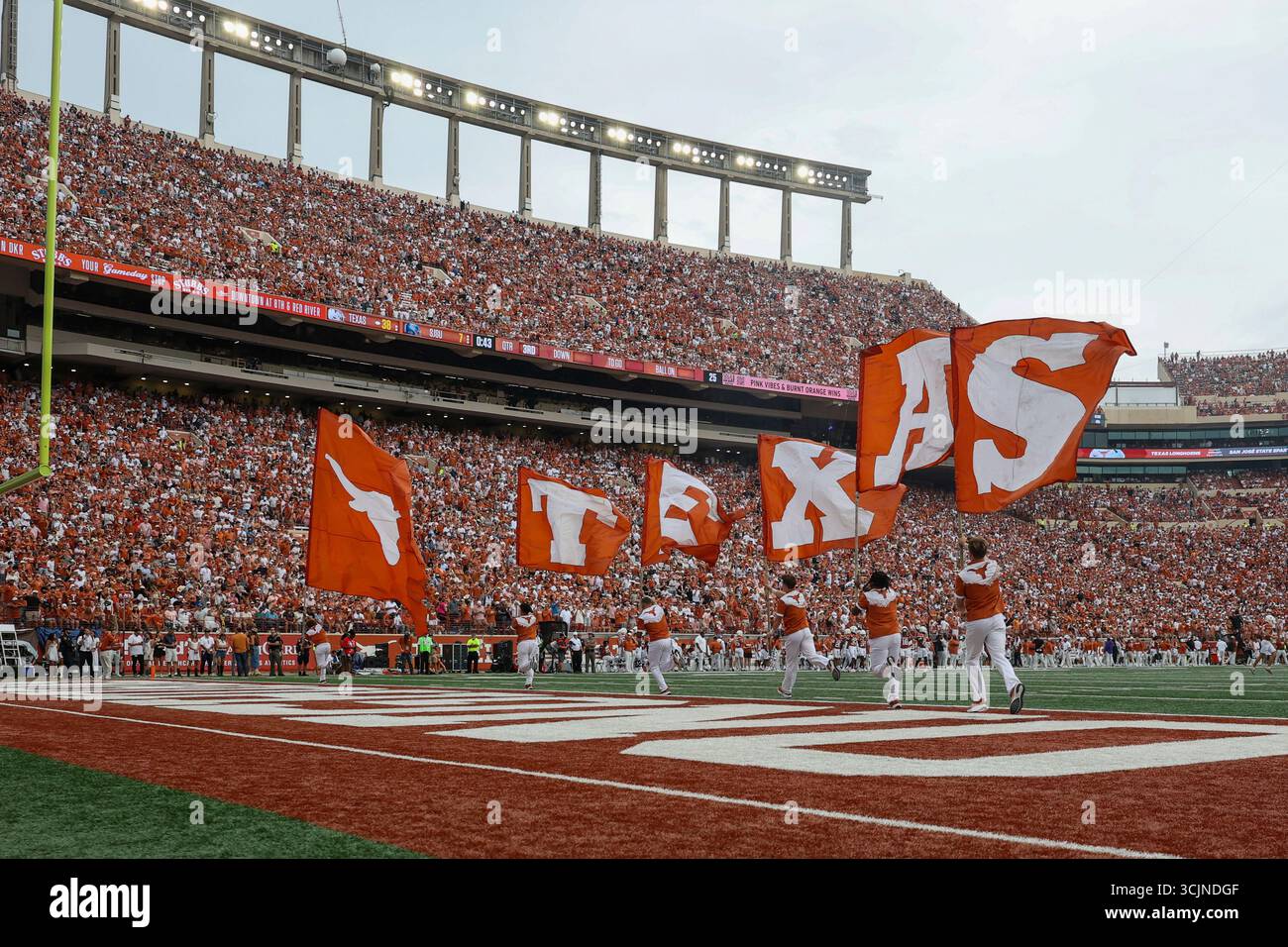 AUSTIN, TX - SEPTEMBER 06: Texas cheerleaders run with flags spelling ...