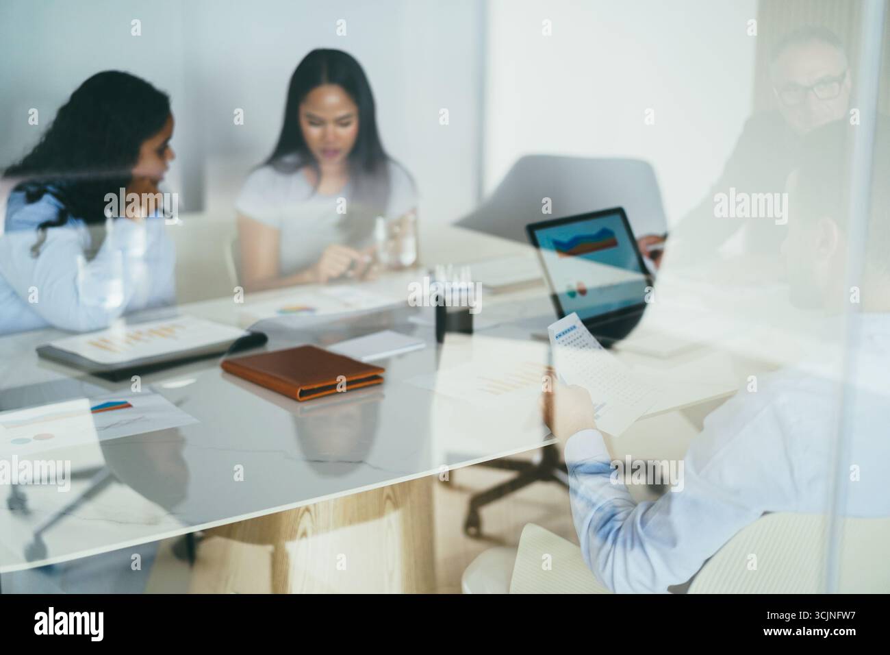 Multiracial colleagues working inside business office with glass walls ...