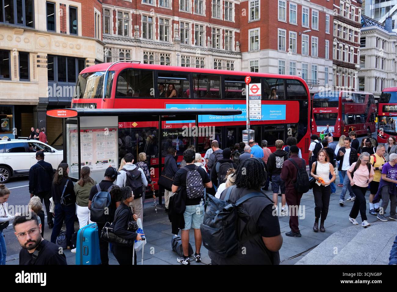 People queue fur buses outside Liverpool Street station in London as ...