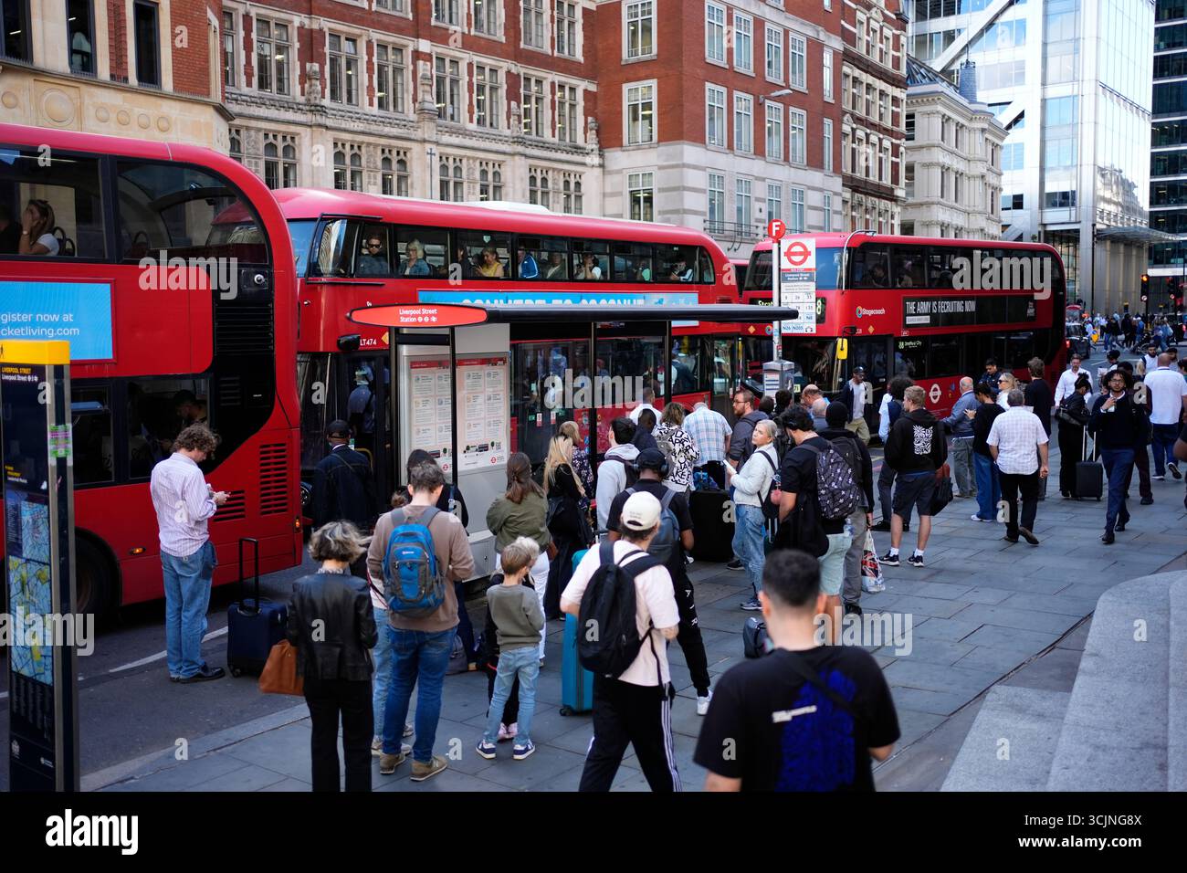 People queue fur buses outside Liverpool Street station in London as ...