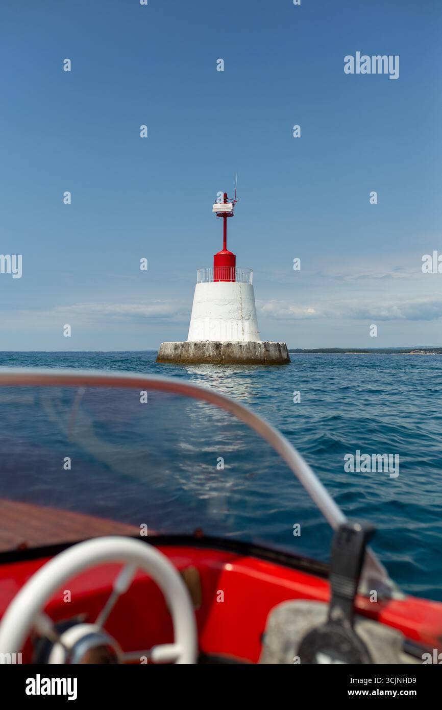 Shot of a red marine beacon on white base in the sea, photographed from ...