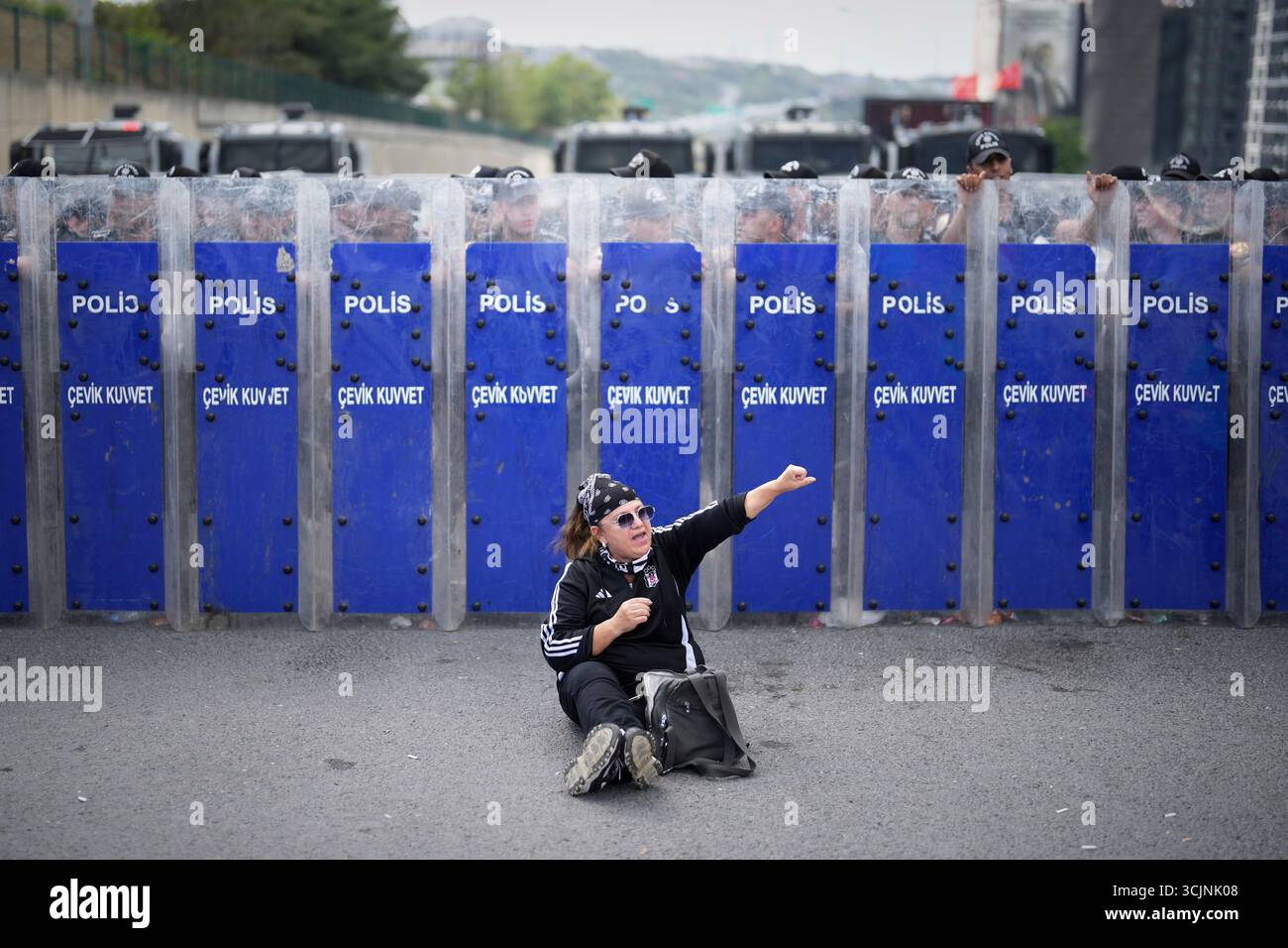 Riot police hold their shields as a supporter of Turkey's main ...